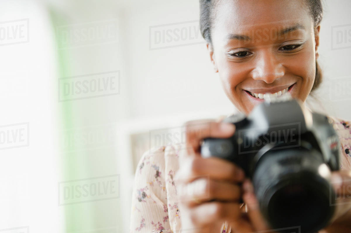 Black woman using digital SLR camera - Royalty-free Stock Photo | Dissolve