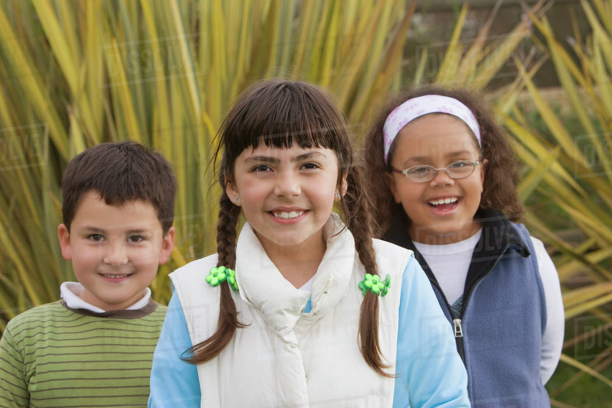 Smiling Hispanic children standing outdoors - Stock Photo - Dissolve