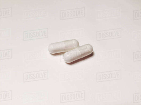 Close up of two white pills - Stock Photo - Dissolve