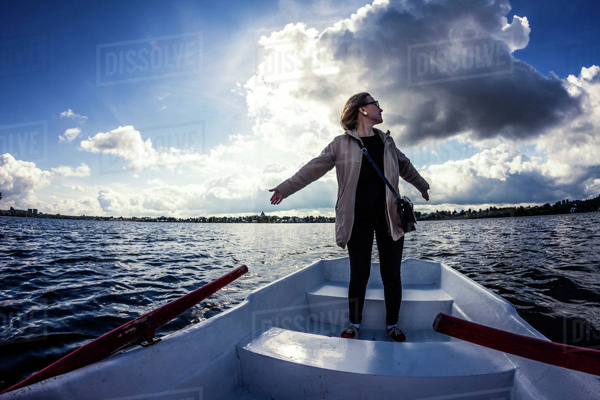 Caucasian woman standing on rowboat - Royalty-free Stock Photo | Dissolve