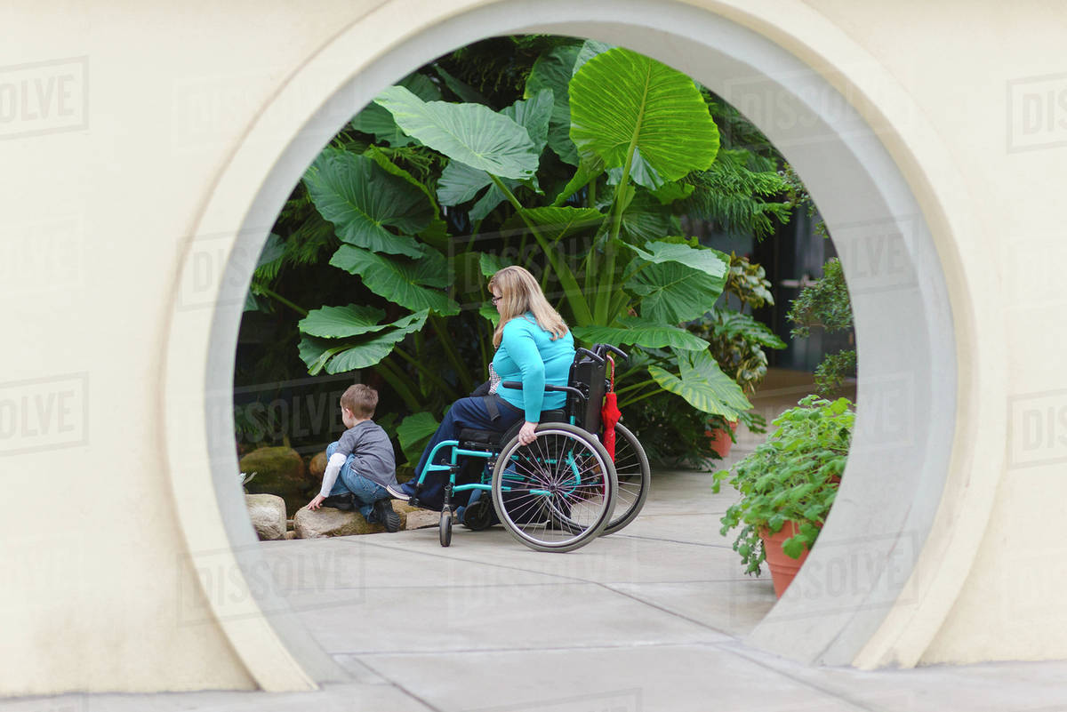 Paraplegic mother and son admiring plants - Royalty-free Stock Photo ...