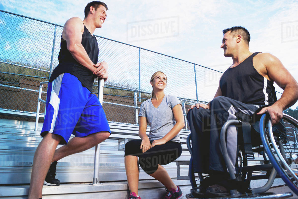 Paraplegic athlete in wheelchair with friends on bleachers - Royalty ...