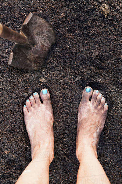 Mixed race woman barefoot in dirt - Stock Photo - Dissolve