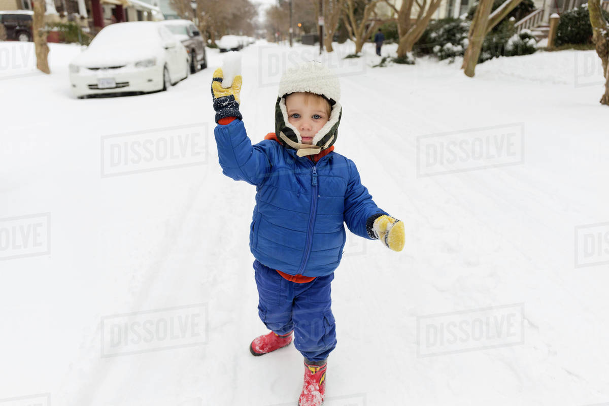 Caucasian boy throwing snowball - Royalty-free Stock Photo | Dissolve