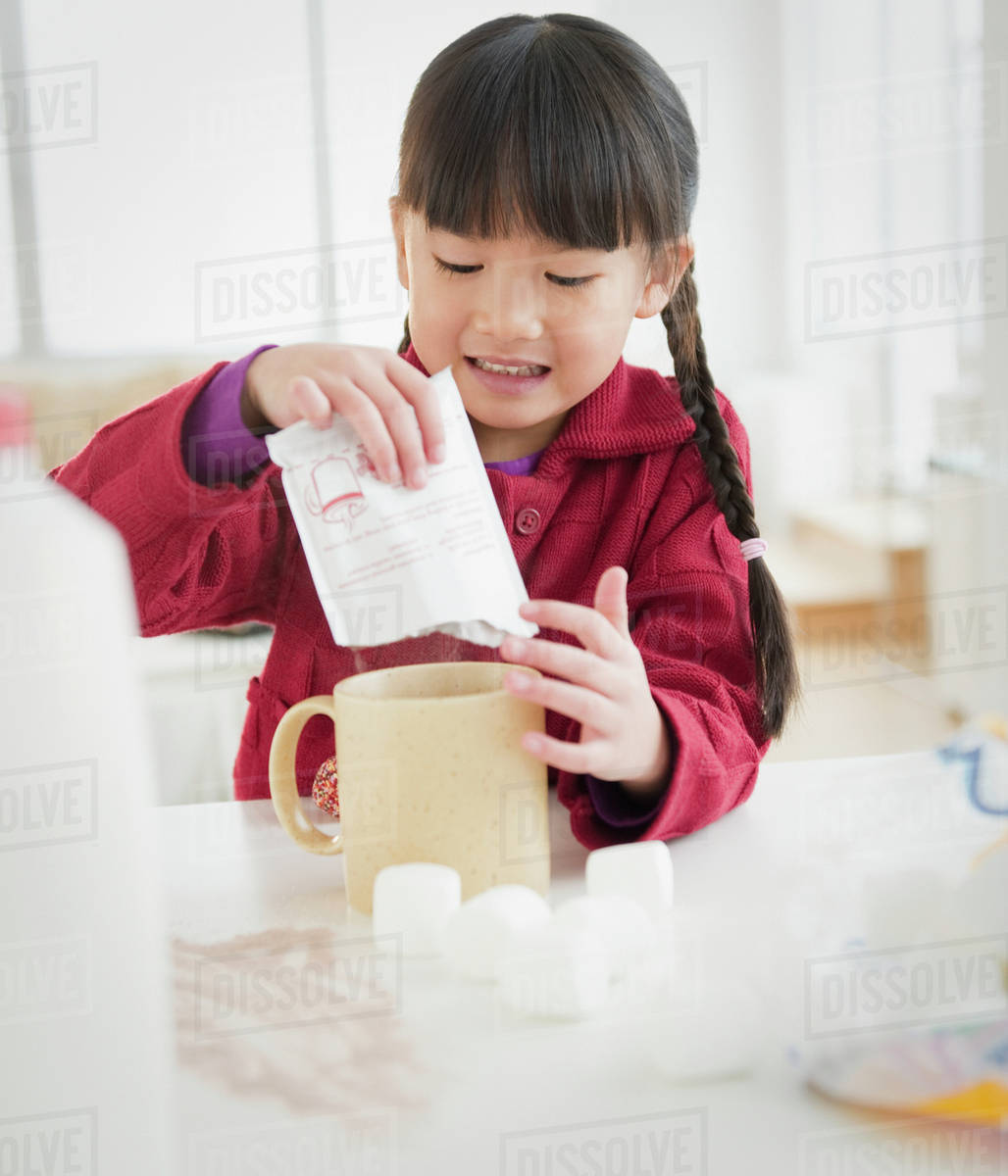 Chinese girl making hot chocolate - Stock Photo - Dissolve