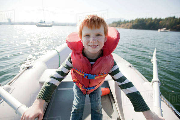 Caucasian boy rowing on boat - Royalty-free Stock Photo | Dissolve