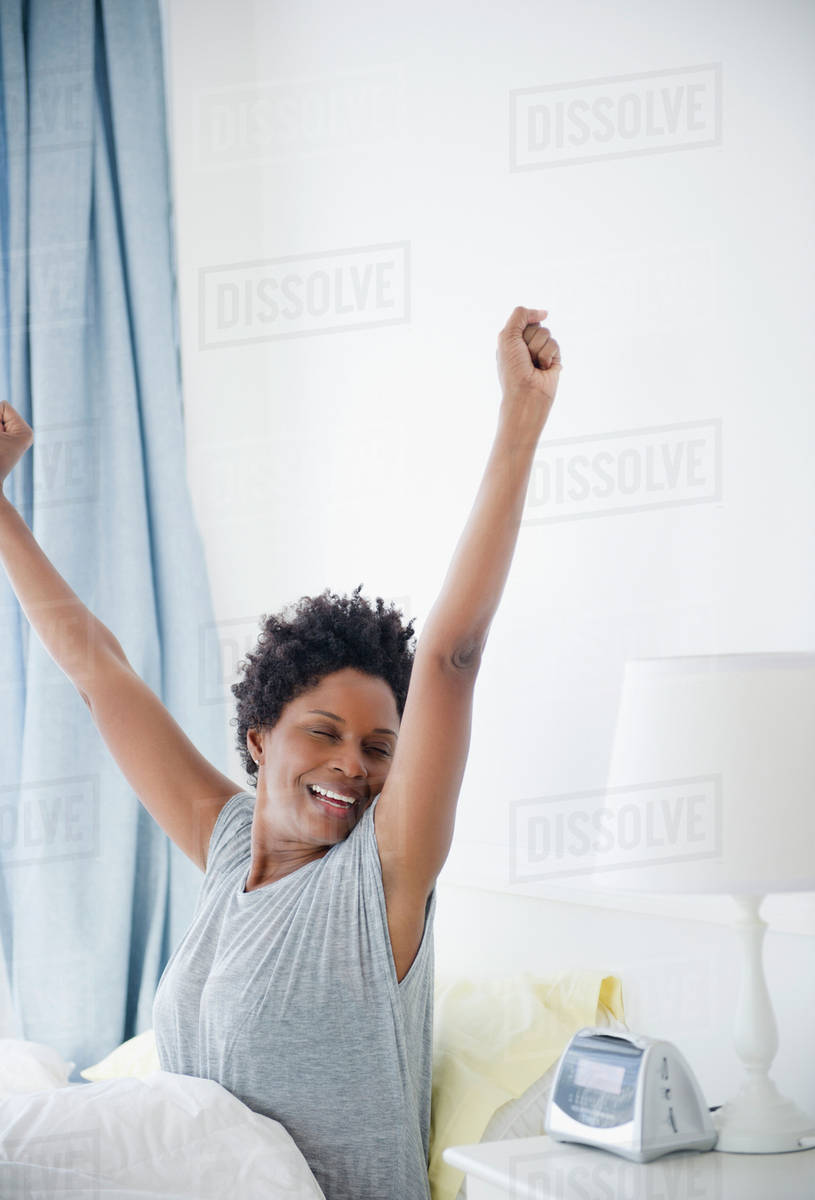 Black woman waking up in the morning - Royalty-free Stock Photo | Dissolve