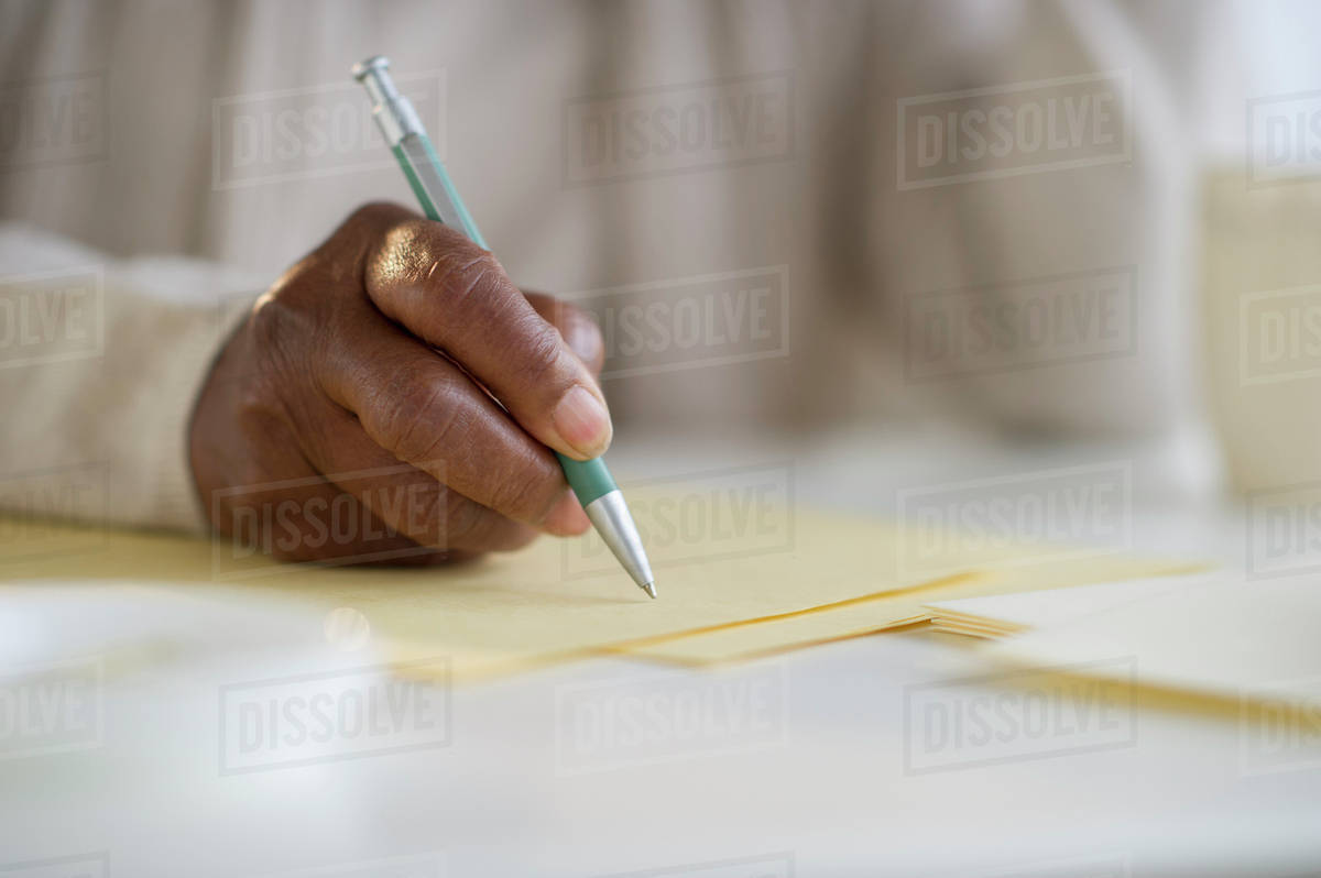 Black woman writing letter - Stock Photo - Dissolve
