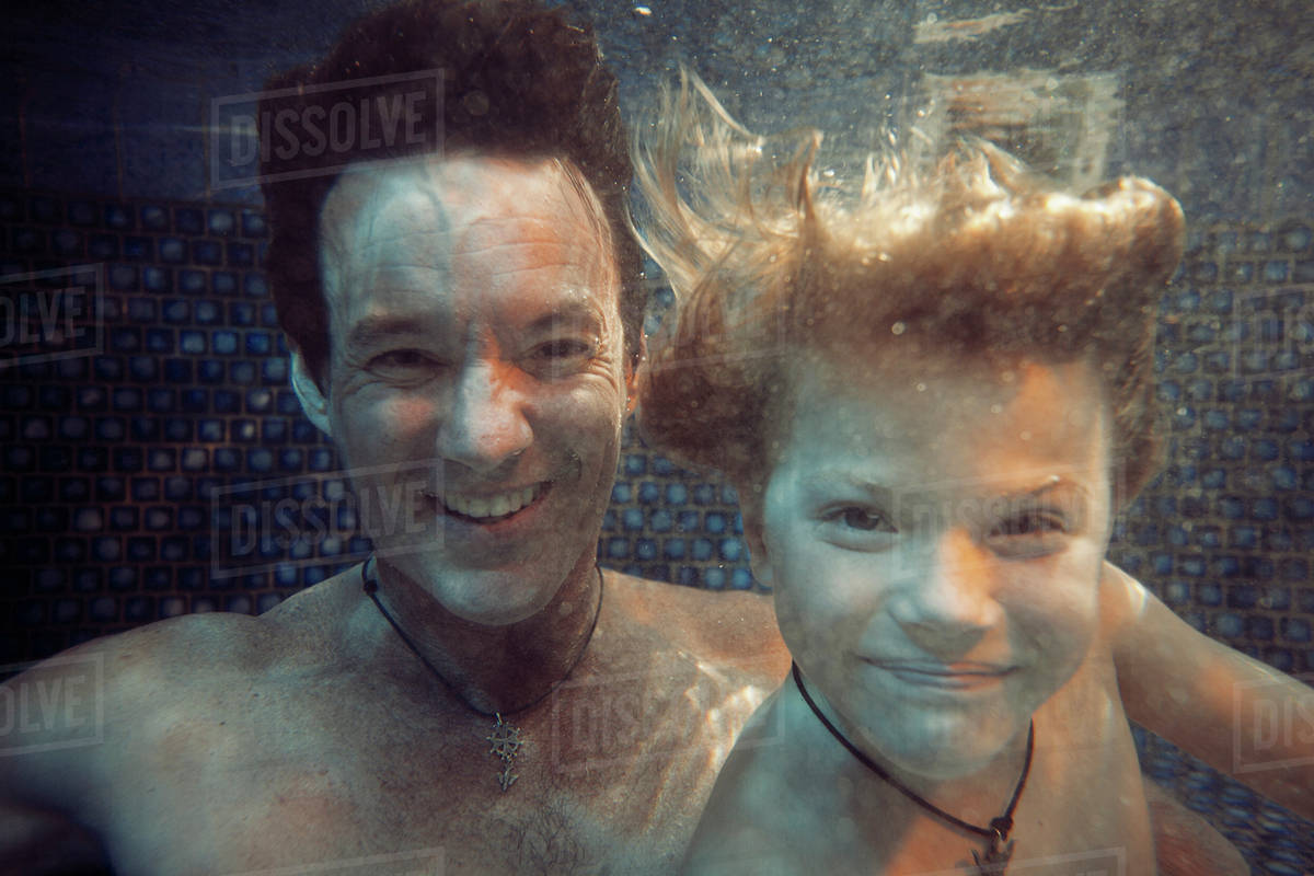 Father and son swimming underwater in swimming pool - Stock Photo ...