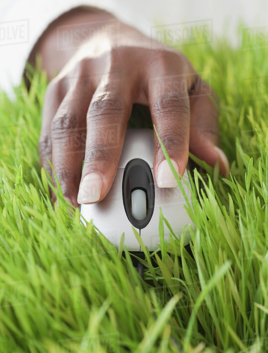 African woman using computer mouse in grass - Royalty-free Stock Photo ...