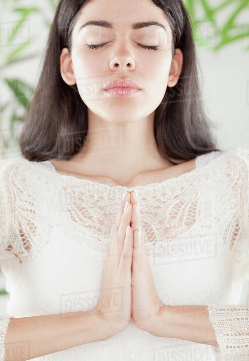 Hispanic woman praying - Royalty-free Stock Photo | Dissolve