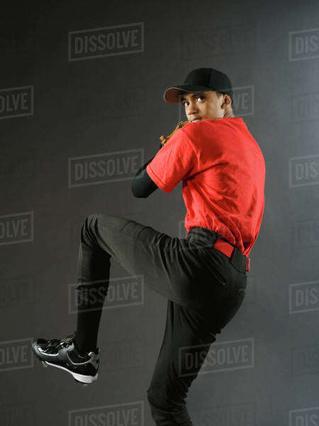 Mixed race baseball pitcher ready to pitch ball - Stock Photo - Dissolve