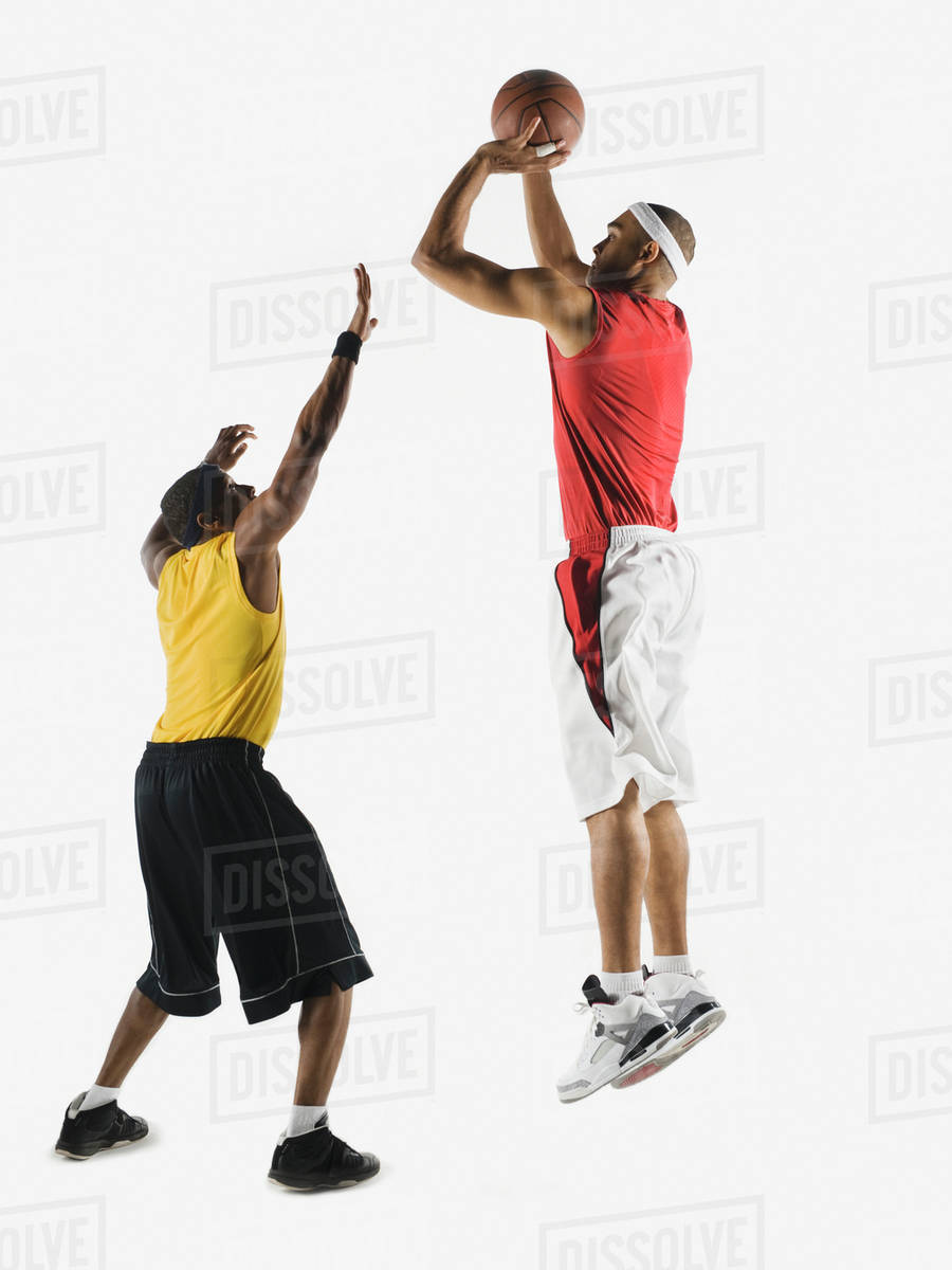 African man shooting basketball over opponent - Royalty-free Stock ...