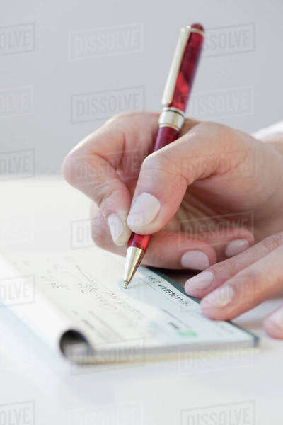 Woman writing personal check - Royalty-free Stock Photo | Dissolve