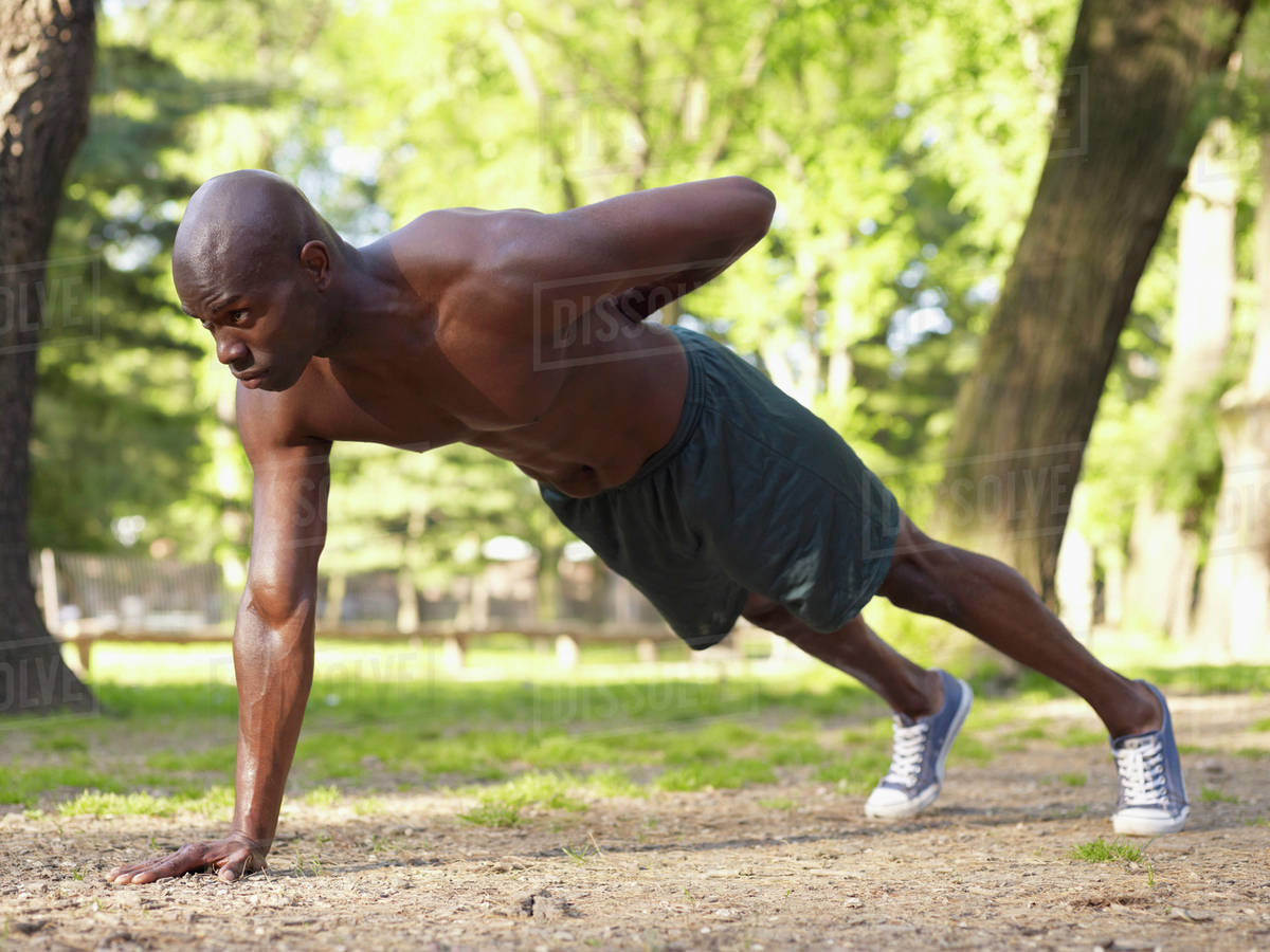 African man doing one arm push-ups in park - Royalty-free Stock Photo ...