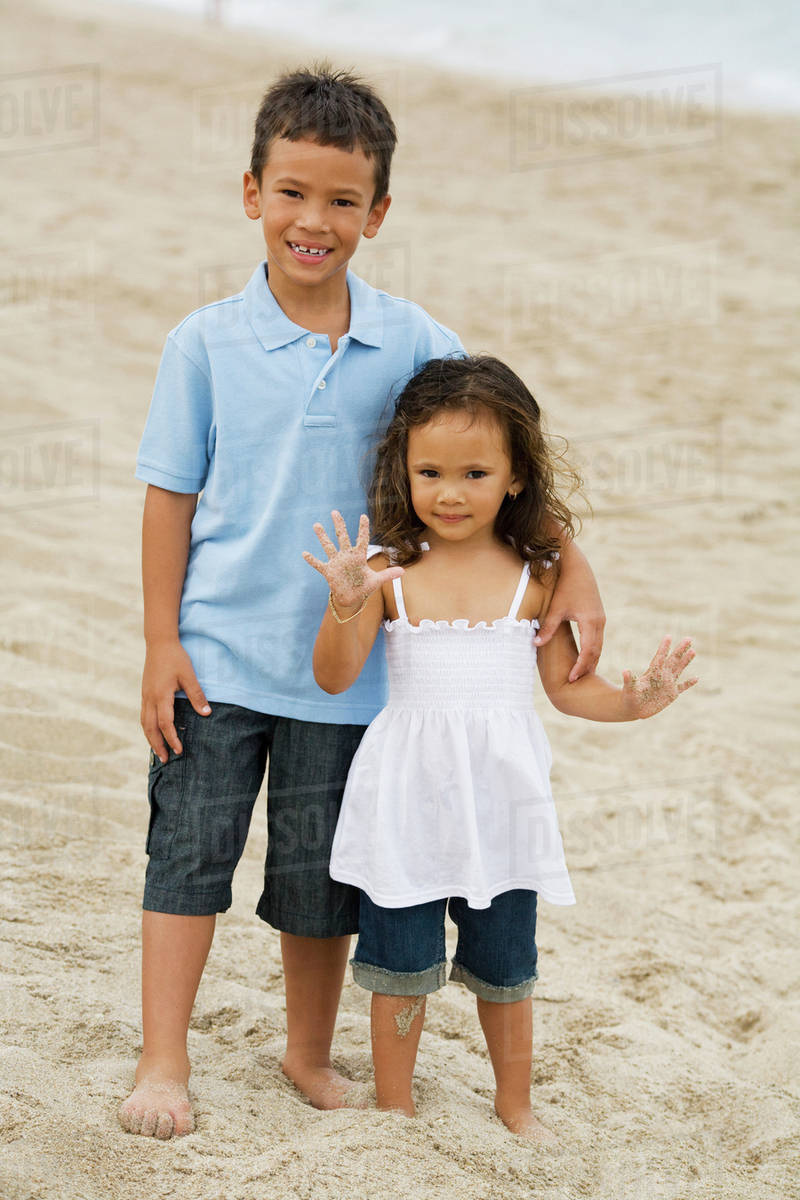 Mixed race brother and sister on beach - Stock Photo - Dissolve