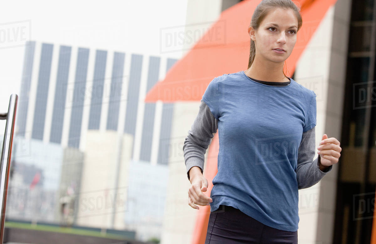 Hispanic woman running in urban area - Royalty-free Stock Photo | Dissolve