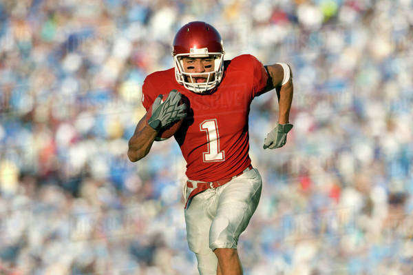 African American football player running on field in game - Royalty ...