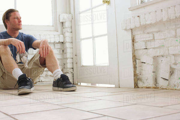 Caucasian man sitting on floor - Royalty-free Stock Photo | Dissolve
