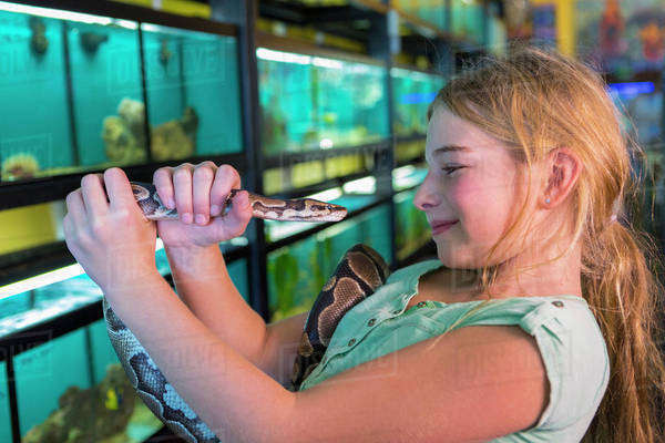 Caucasian girl admiring snake in pet store - Royalty-free Stock Photo ...