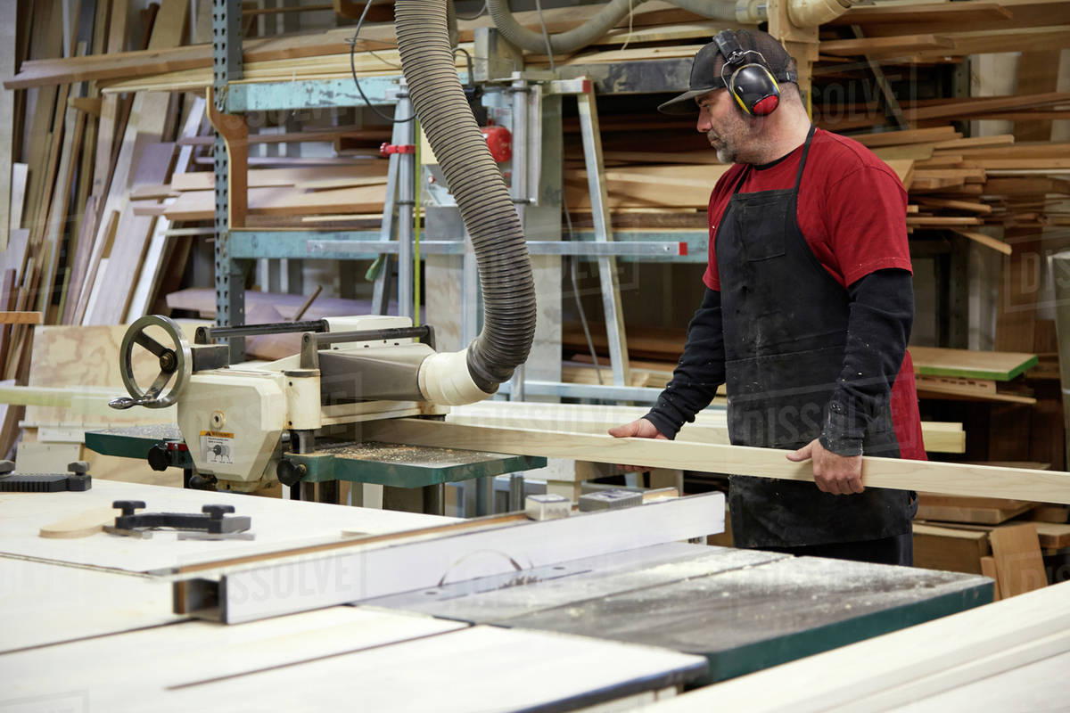 Carpenter using saw in workshop - Royalty-free Stock Photo | Dissolve