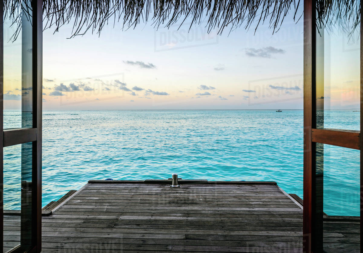 Wooden dock and ocean at sunset - Stock Photo - Dissolve