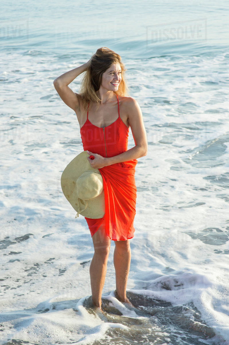 Caucasian woman standing in waves on beach - Royalty-free Stock Photo ...