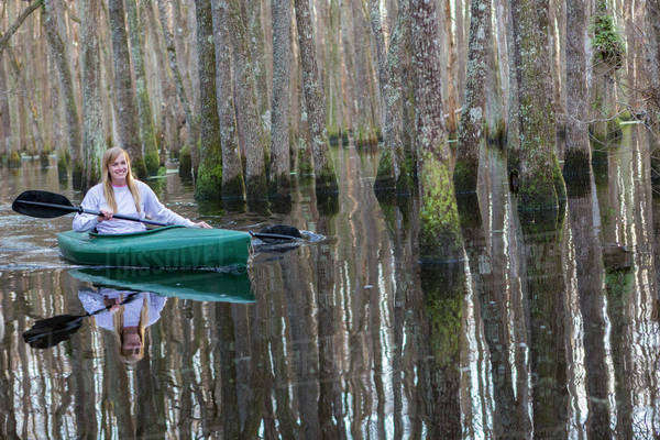 Caucasian woman rowing canoe in river - Royalty-free Stock Photo | Dissolve