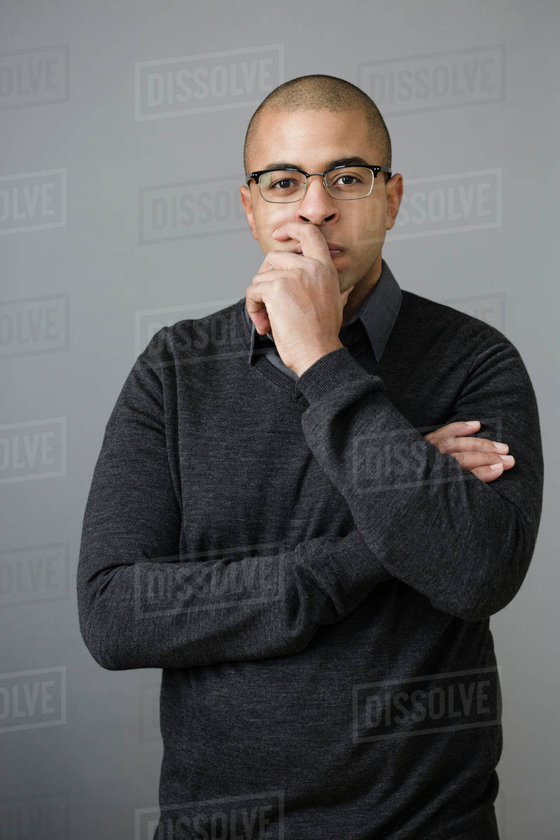 Mixed race man holding chin in hand - Royalty-free Stock Photo | Dissolve