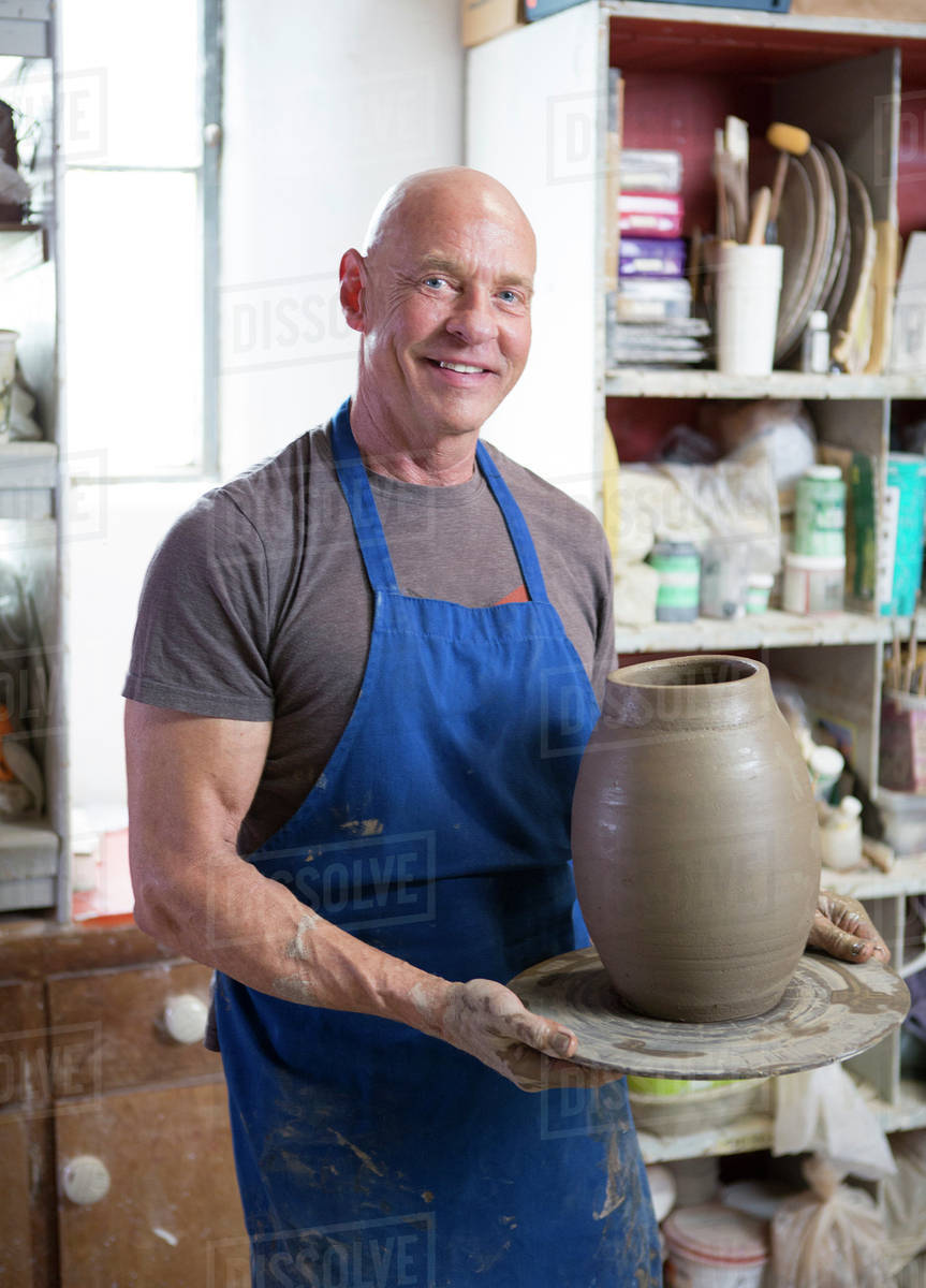 Proud older Caucasian man holding pottery in ceramics studio - Stock ...