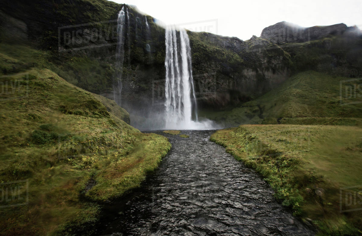 Waterfall pouring over rocky cliff - Royalty-free Stock Photo | Dissolve