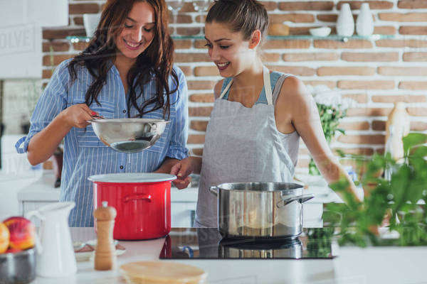 Caucasian women cooking in kitchen - Royalty-free Stock Photo | Dissolve