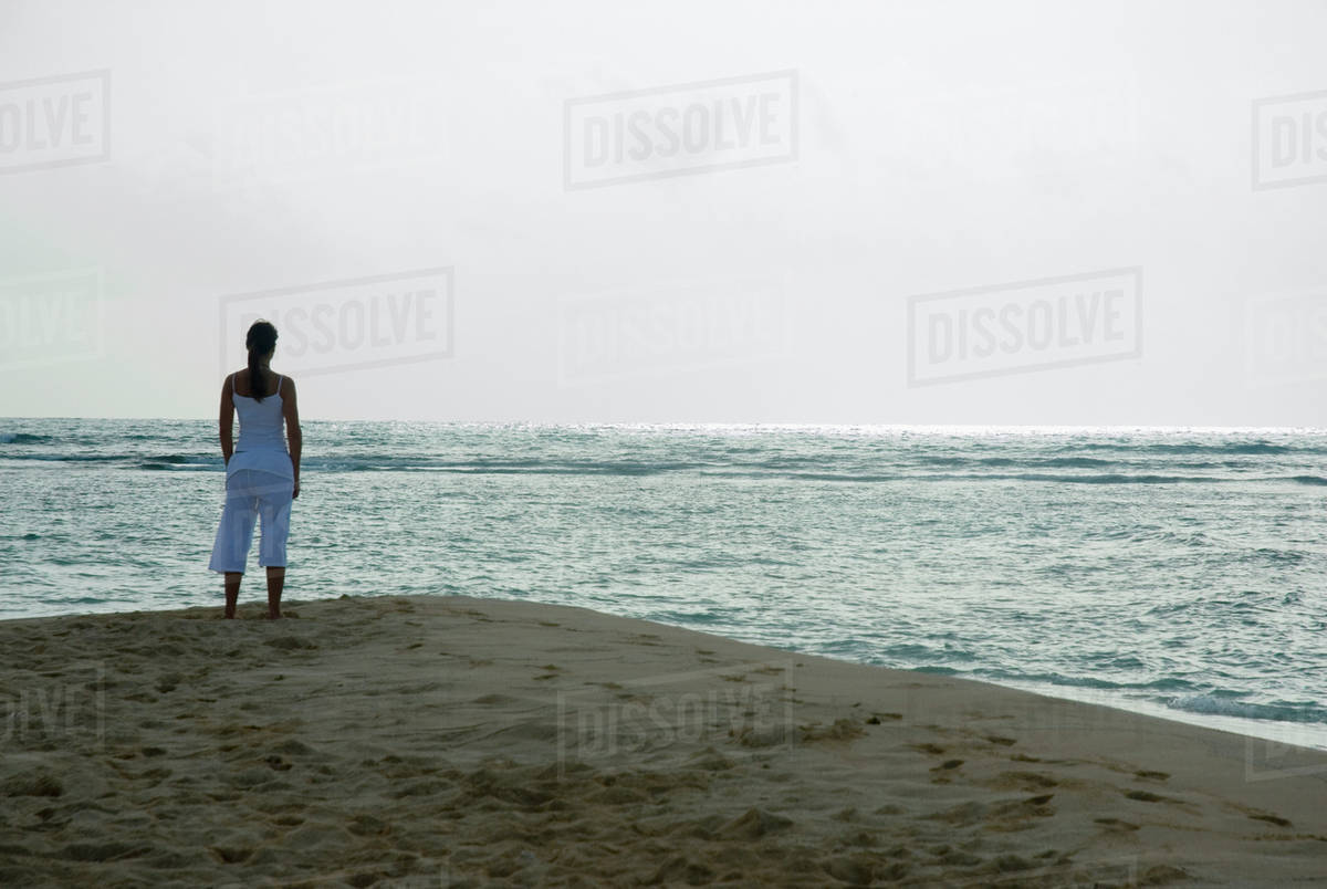 Woman looking out over ocean - Royalty-free Stock Photo | Dissolve
