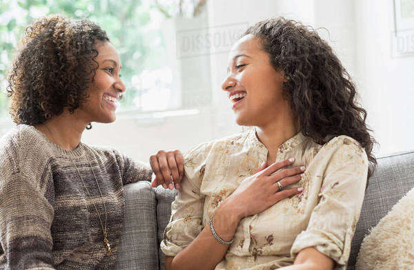 Laughing women talking on sofa - Stock Photo - Dissolve