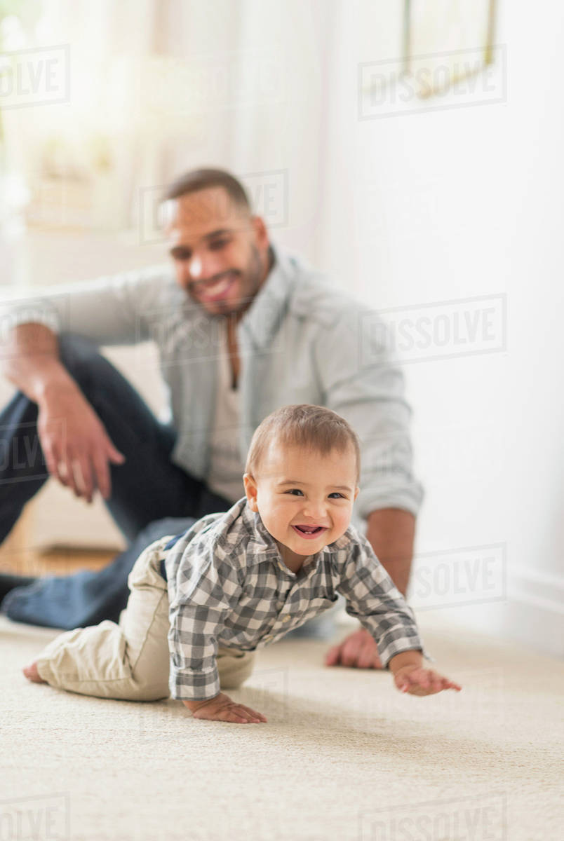 Father watching baby son crawling on floor - Royalty-free Stock Photo ...