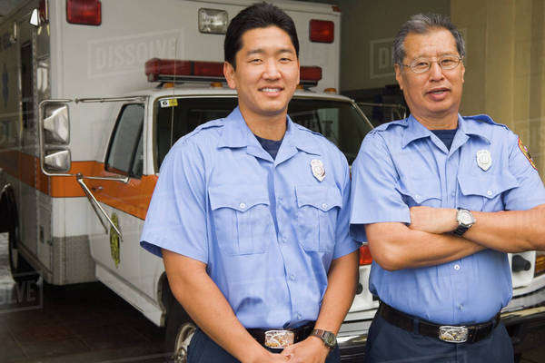 Asian male paramedics in front of ambulance - Stock Photo - Dissolve