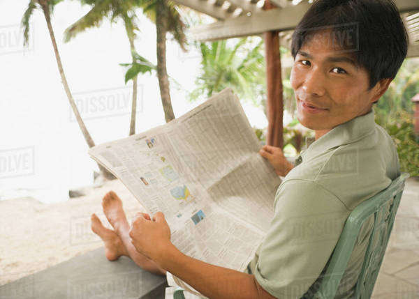 Asian man reading newspaper - Royalty-free Stock Photo | Dissolve