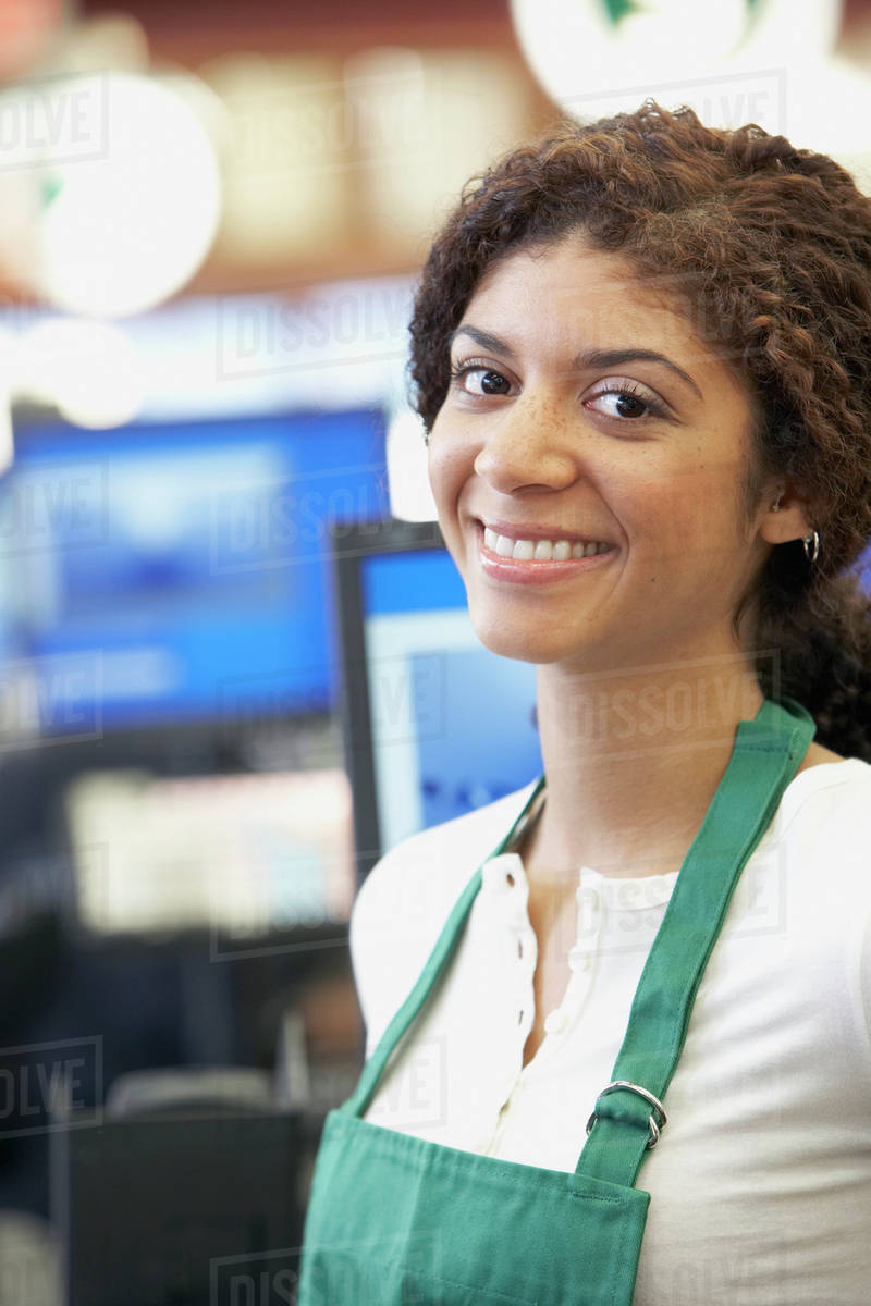 Mixed Race cashier wearing apron - Royalty-free Stock Photo | Dissolve