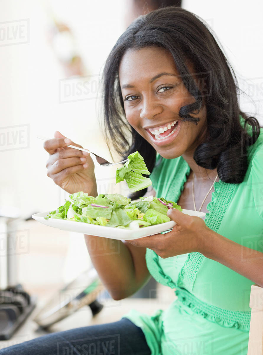 African woman eating salad - Royalty-free Stock Photo | Dissolve