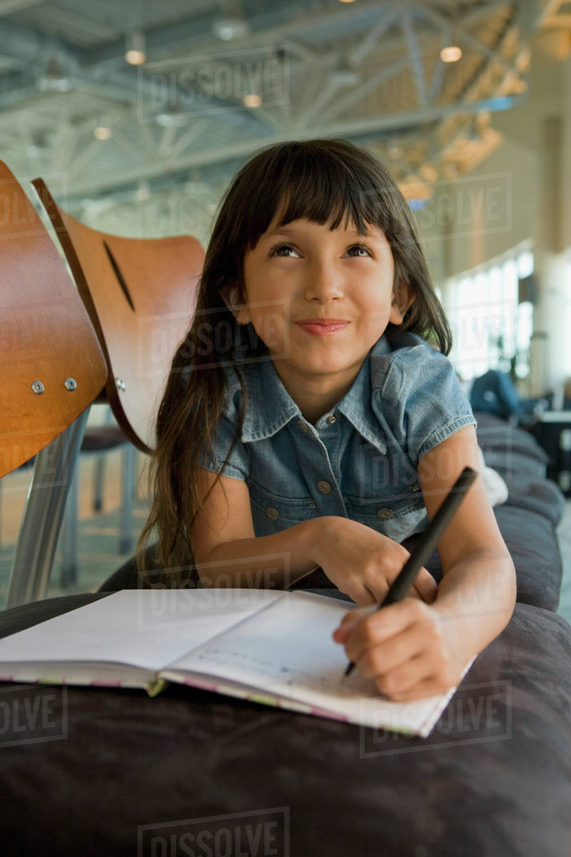 Hispanic girl writing in diary in airport - Royalty-free Stock Photo ...