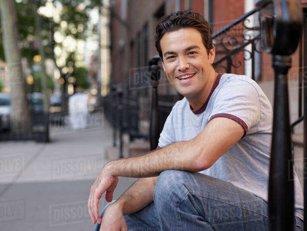 Man sitting on front stoop - Stock Photo - Dissolve