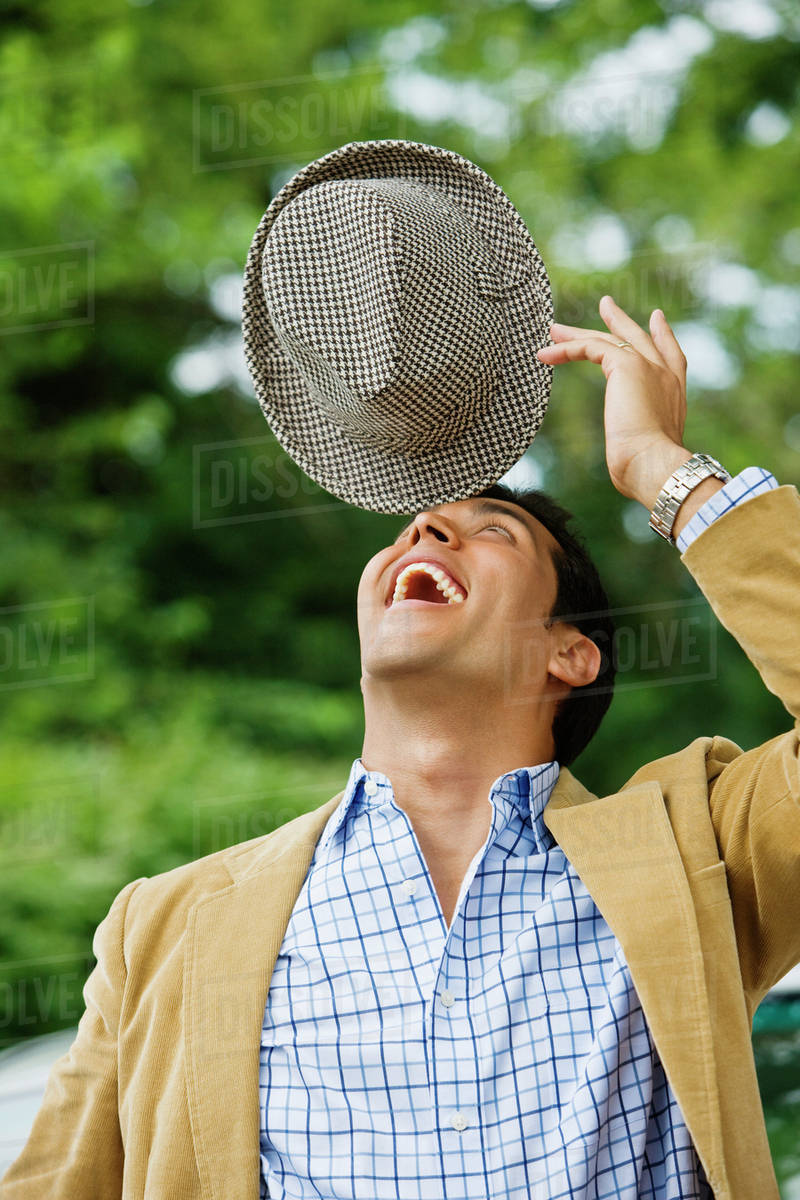 Hispanic man balancing hat - Royalty-free Stock Photo | Dissolve