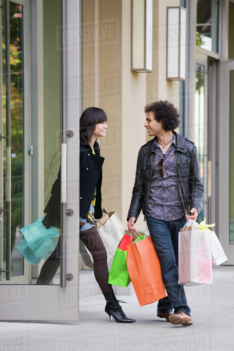 Couple leaving store with shopping bags - Royalty-free Stock Photo ...