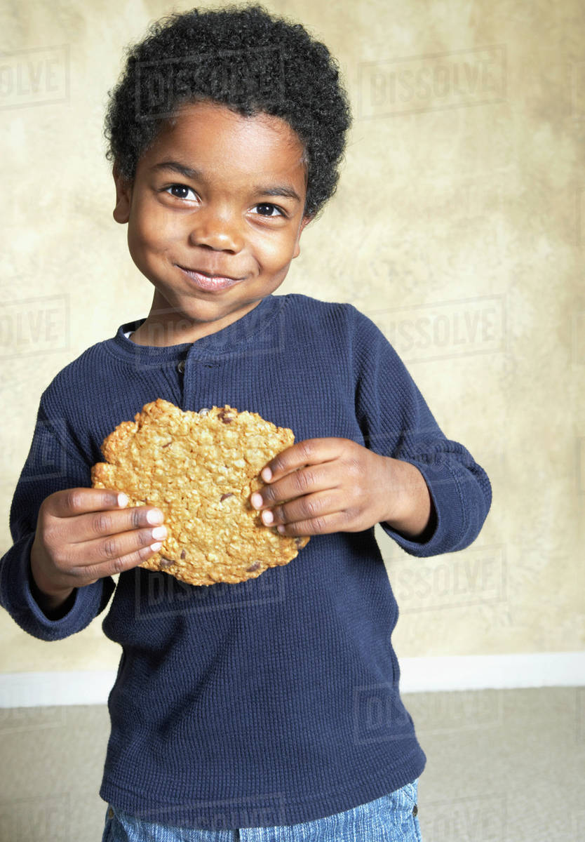 Young African American boy eating large cookie - Royalty-free Stock ...