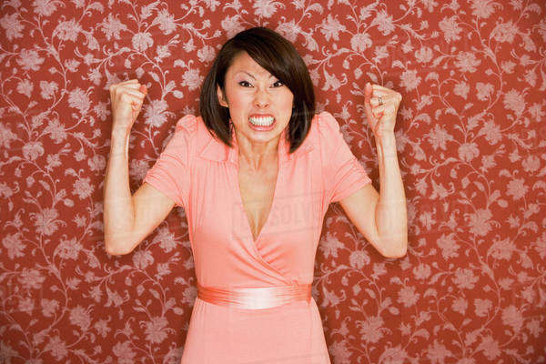 Angry Asian woman with hands in fists - Stock Photo - Dissolve