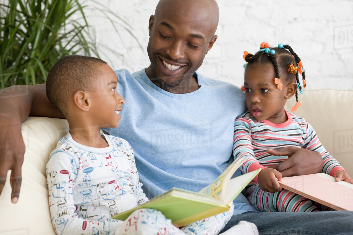 African father reading to children - Royalty-free Stock Photo | Dissolve