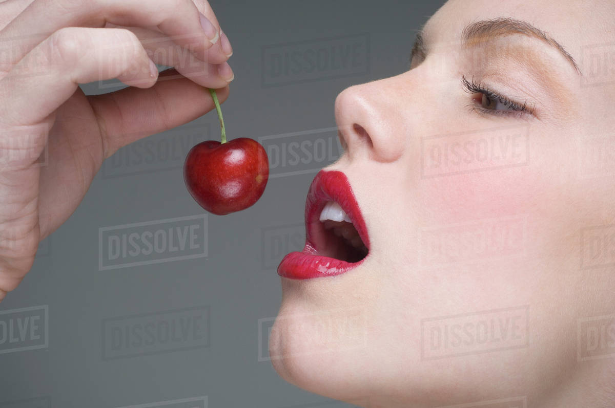 Woman eating cherry - Royalty-free Stock Photo | Dissolve