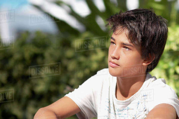 Pacific Islander boy sitting outdoors - Royalty-free Stock Photo | Dissolve