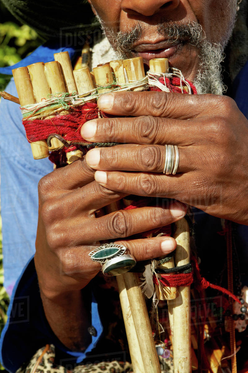 Close up of African man playing pan flute - Stock Photo - Dissolve