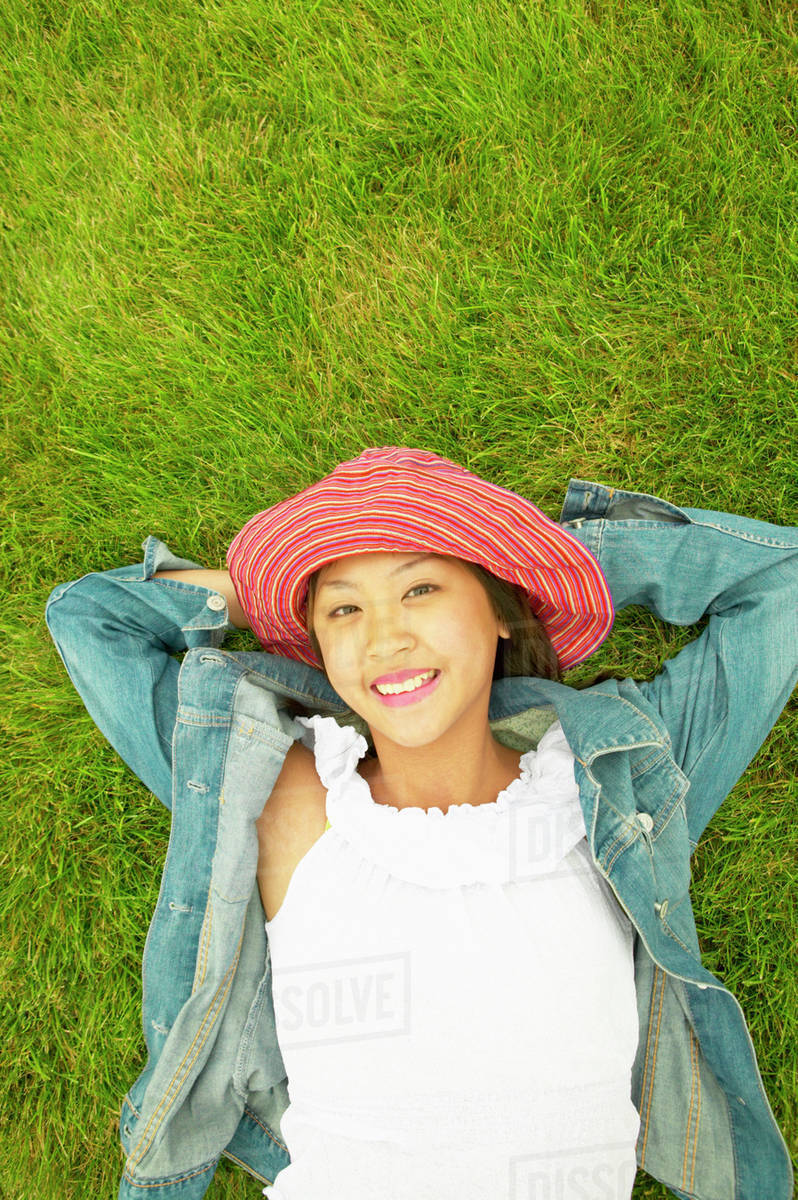Portrait of woman laying in grass - Royalty-free Stock Photo | Dissolve